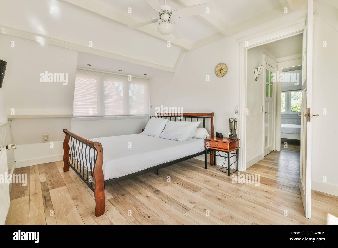 Comfortable bed with white bedclothes and bedside table with lamp ...