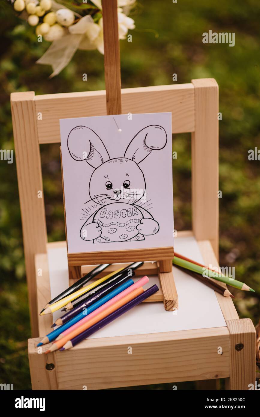 A vertical shot of a drawing of a bunny with colorful pencils in a ...