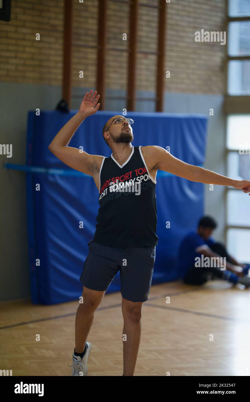 A vertical shot of a young male hitting a volleyball during a game in ...