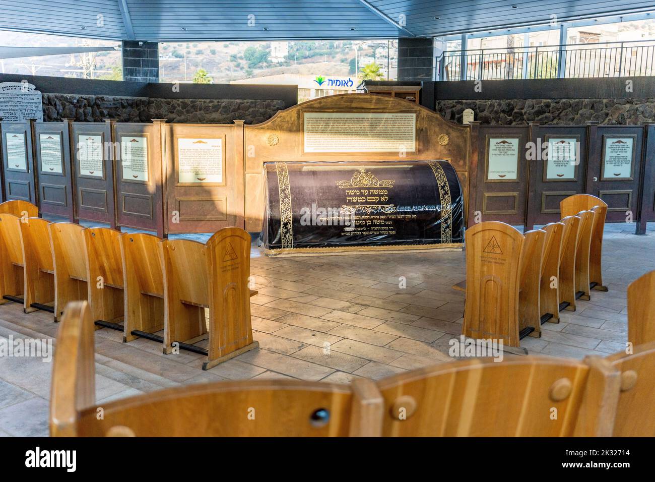 An inside view of the tomb of Maimonides with wooden chairs and a ...