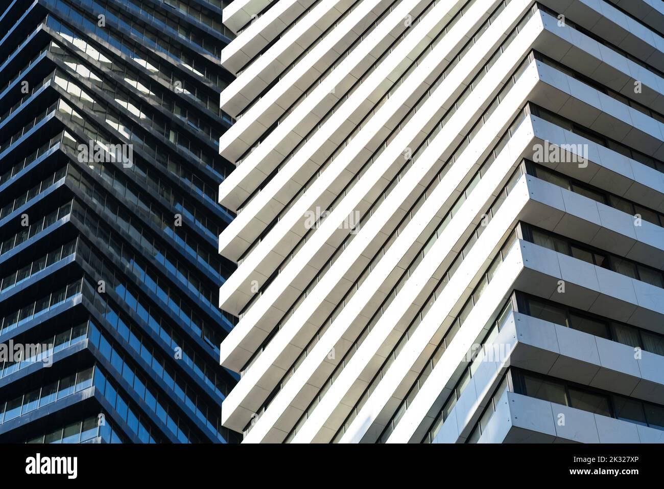 High-rise skyscraper buildings walls in shadow and at bright sunlight ...