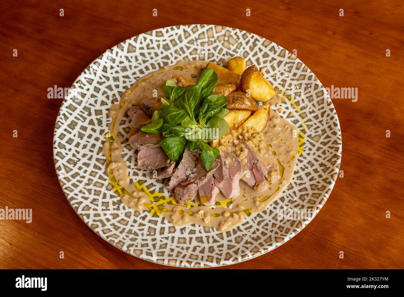 A plate of creamy beef stew with fries and herbs Stock Photo - Alamy
