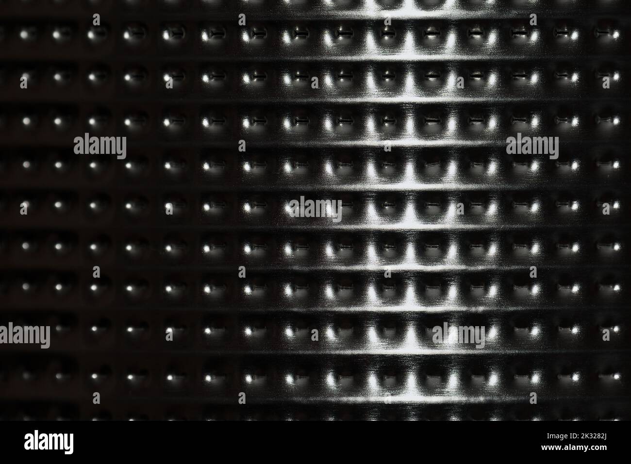 The outer side of a round metal container with dimples and nodules on ...