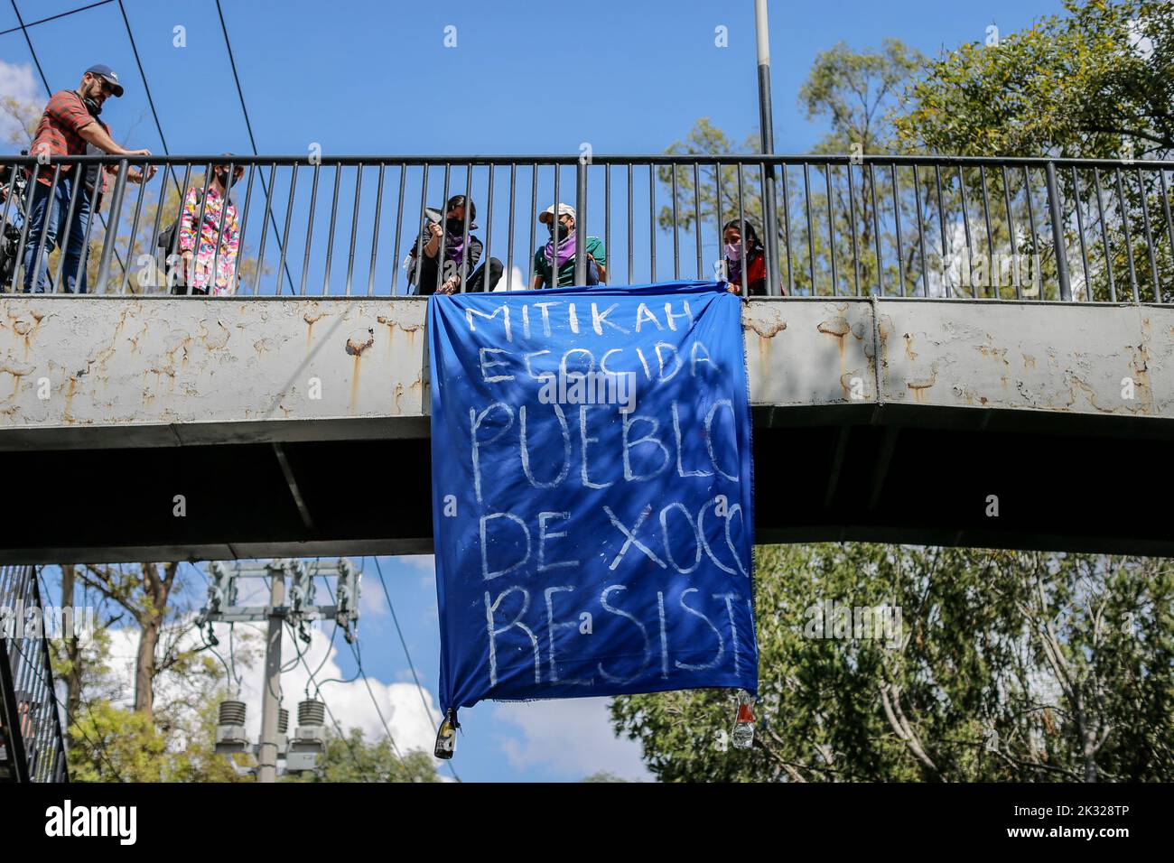 Protesters place a banner on a pedestrian bridge during a demonstration ...