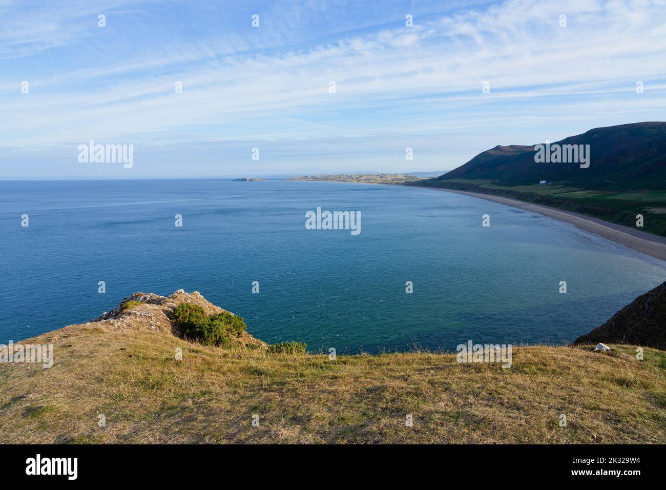 Summer sunlight begins to creep across Rhossili Bay on the Gower ...
