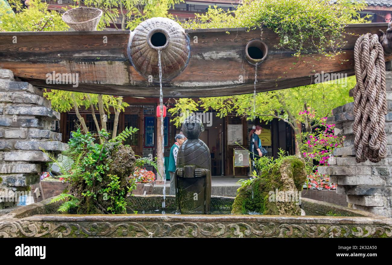 An ancient stone figure faces a man-made waterfall at the ancient town ...