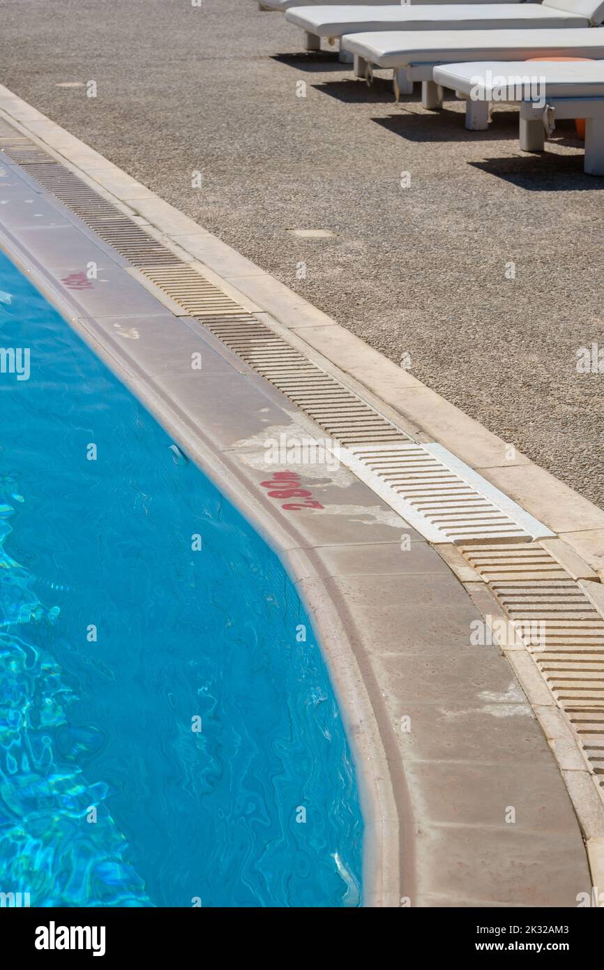View of a swimming pool and sun beds Stock Photo - Alamy