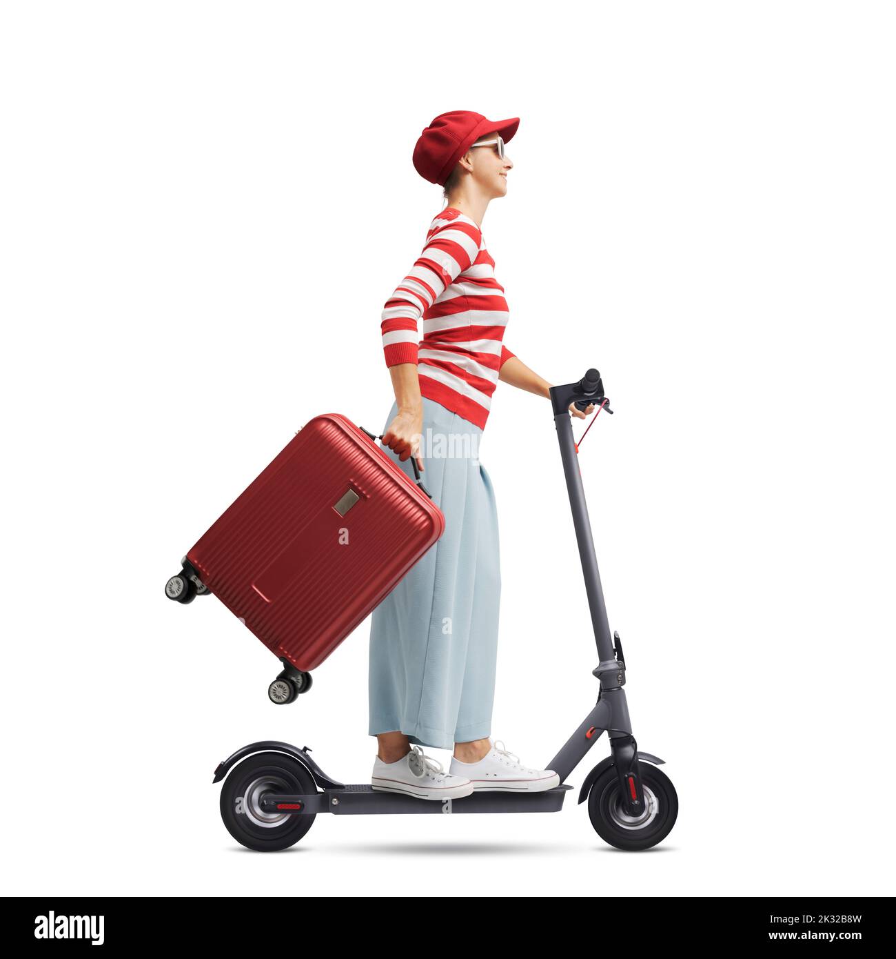 Young woman carrying a trolley bag and riding a fast electric scooter ...