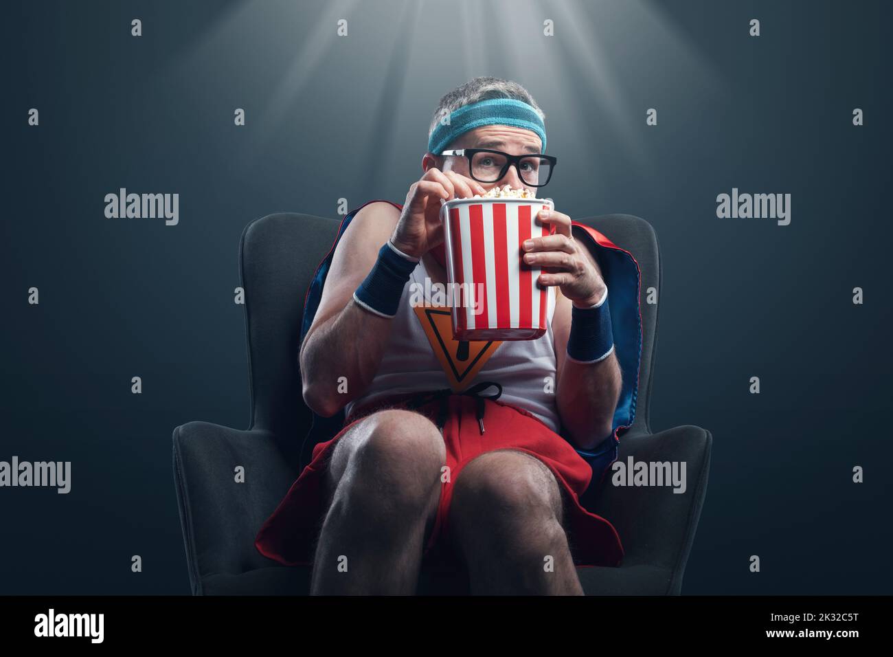 Funny superhero watching horror movies and eating popcorn, he is ...