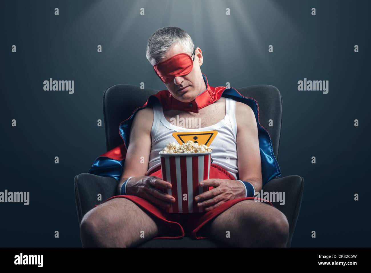Funny superhero watching a boring movie, he is sleeping with a sleep ...
