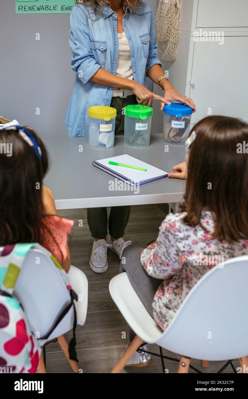 Teacher and students in an ecology classroom learning to recycle by ...