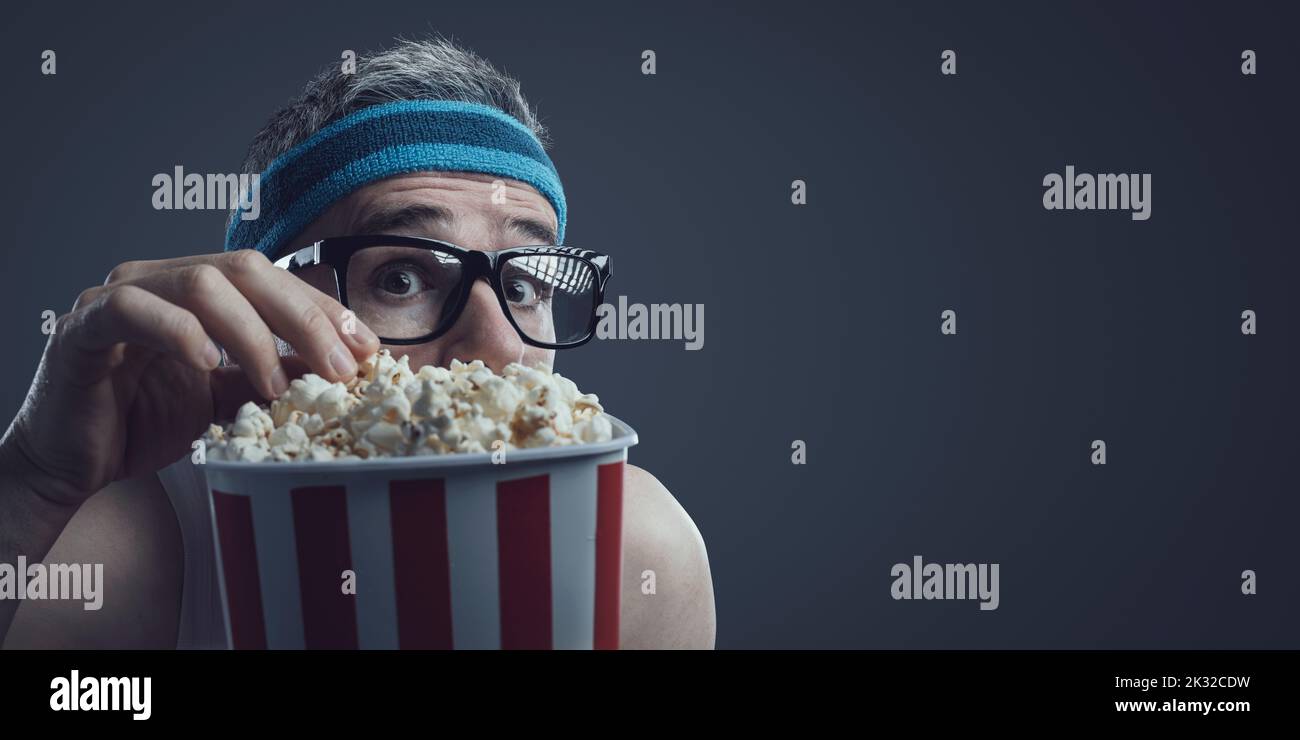 Funny scared guy watching horror movies and eating popcorn, blank copy ...