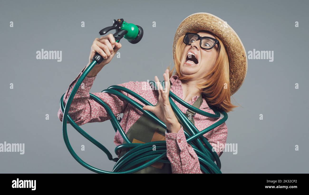 Funny bad gardener tied up with garden hose and shouting Stock Photo ...