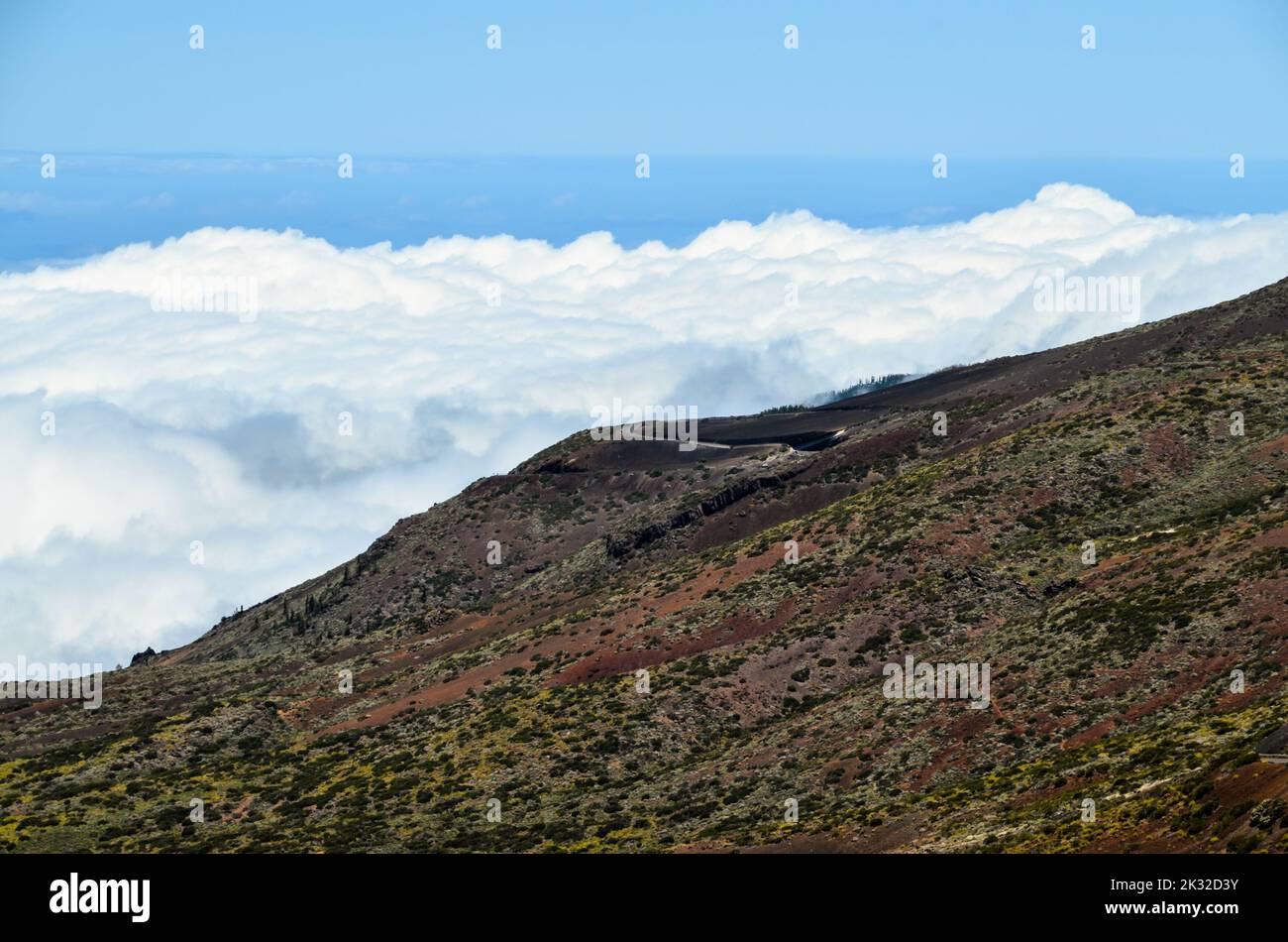 The view of a mountain slope over the clouds under the blue sky Stock ...