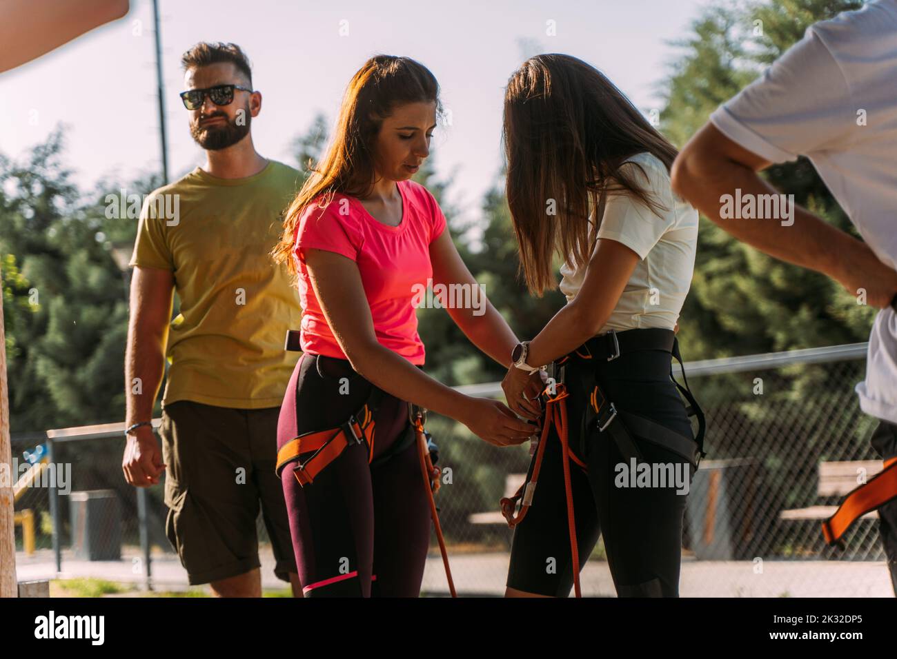 Two beautiful girls in the adventue park putting on the protectors ...