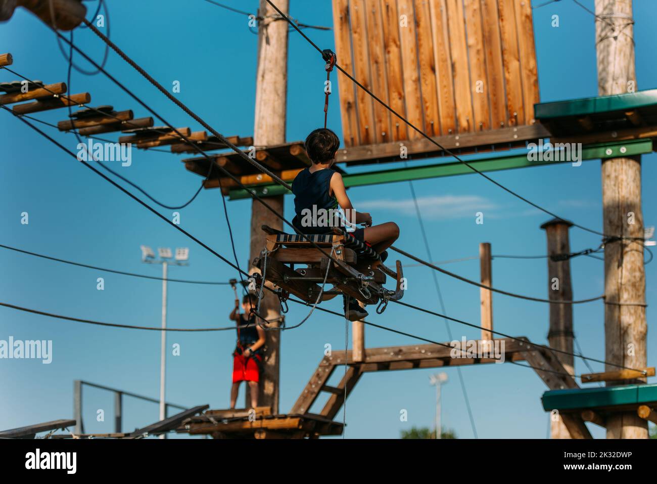 Young small boy riding a sled on the ropes in the adventure park Stock ...