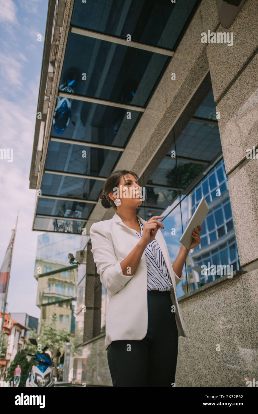Beautiful business woman looking looking at the building while standing ...