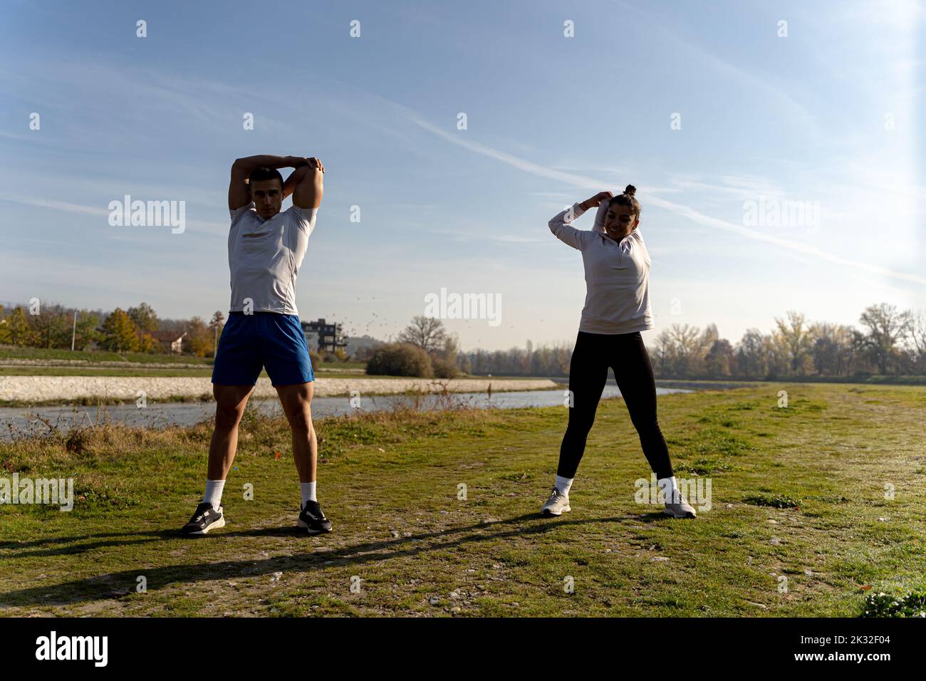 Two amazing and attractive fit friends are exercising together and ...