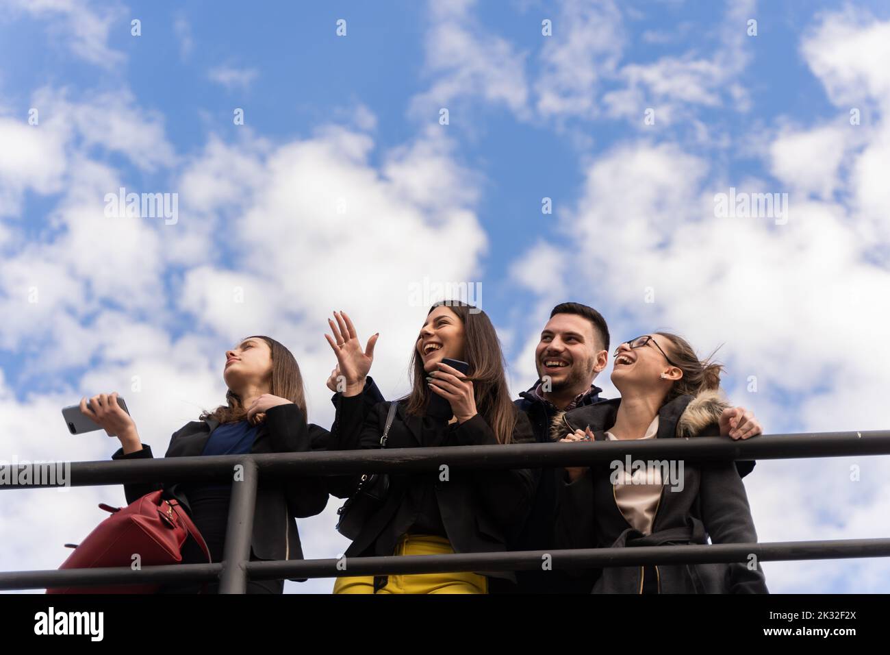 Group of amazing and young business people are laughing together while ...