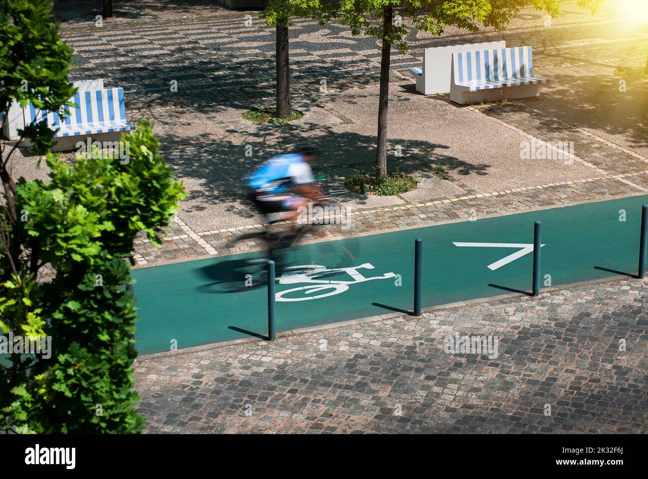Man in motion riding a road bike on a bicycle path with a bicycle lane ...