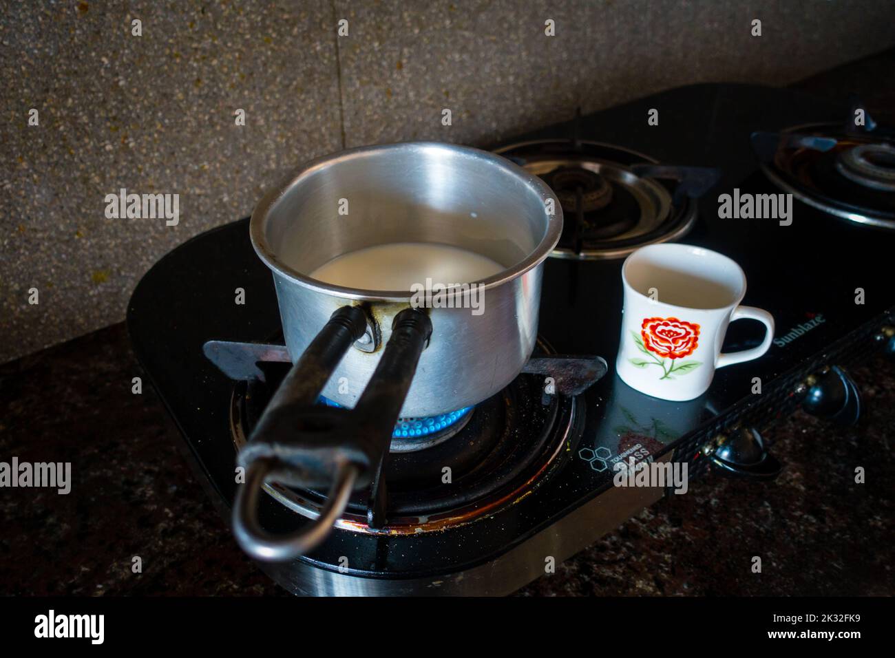 Milk Tea preparation on a gas stove in an Indian House hold Kitchen ...
