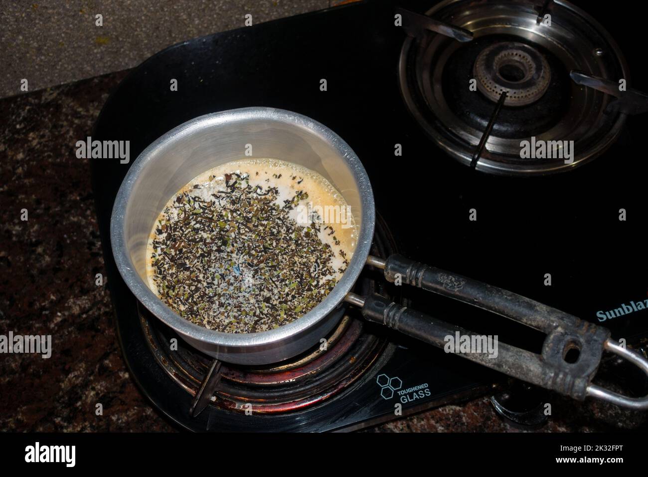 Milk Tea preparation on a gas stove in an Indian House hold Kitchen ...