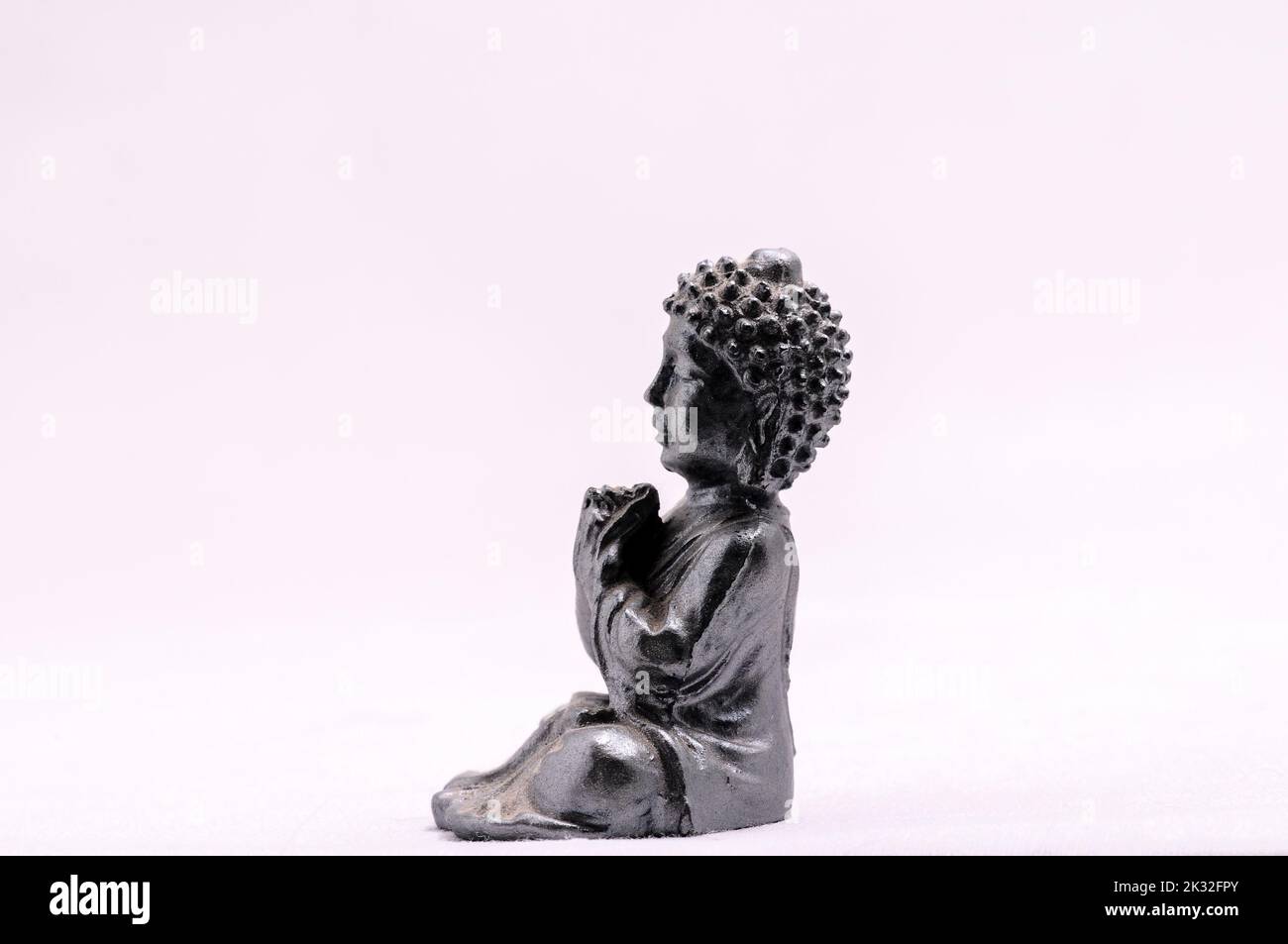 An oriental asian meditating statue on white background Stock Photo - Alamy