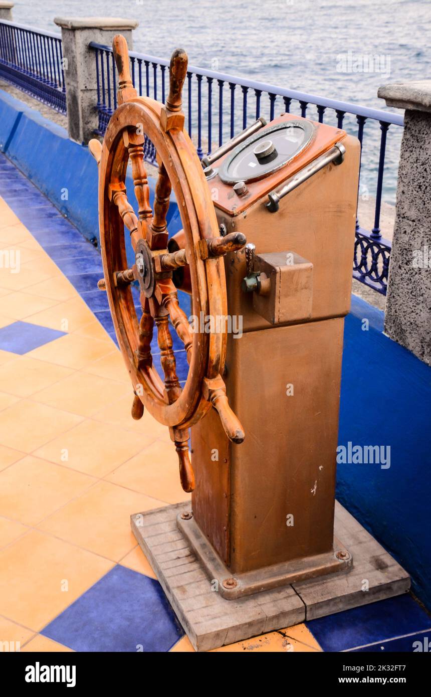 A vertical view of the old wooden vintage helm wheel by the fence ...