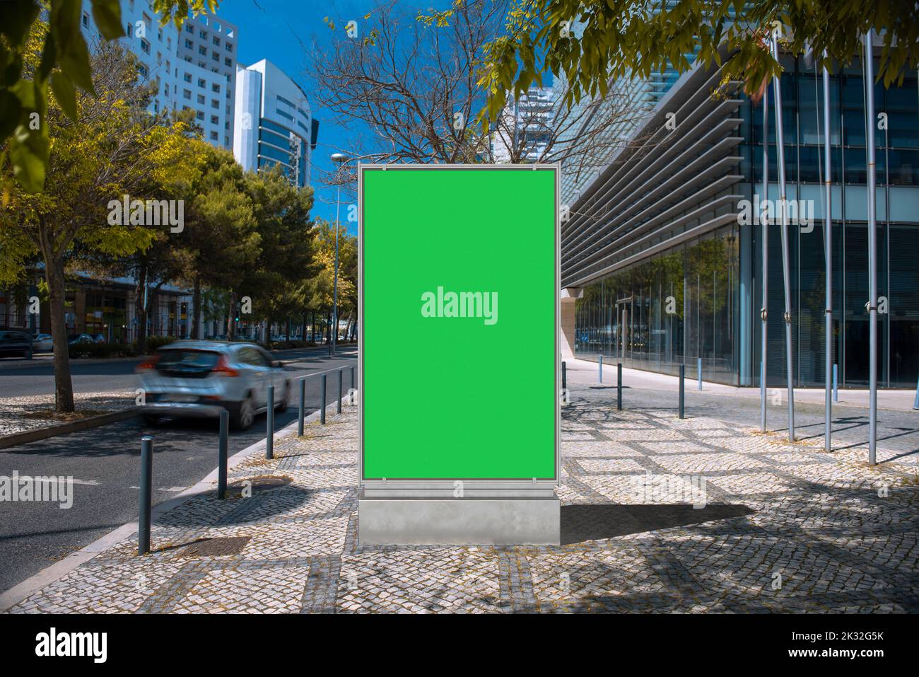 Blank billboard with a green screen on the street with modern buildings ...
