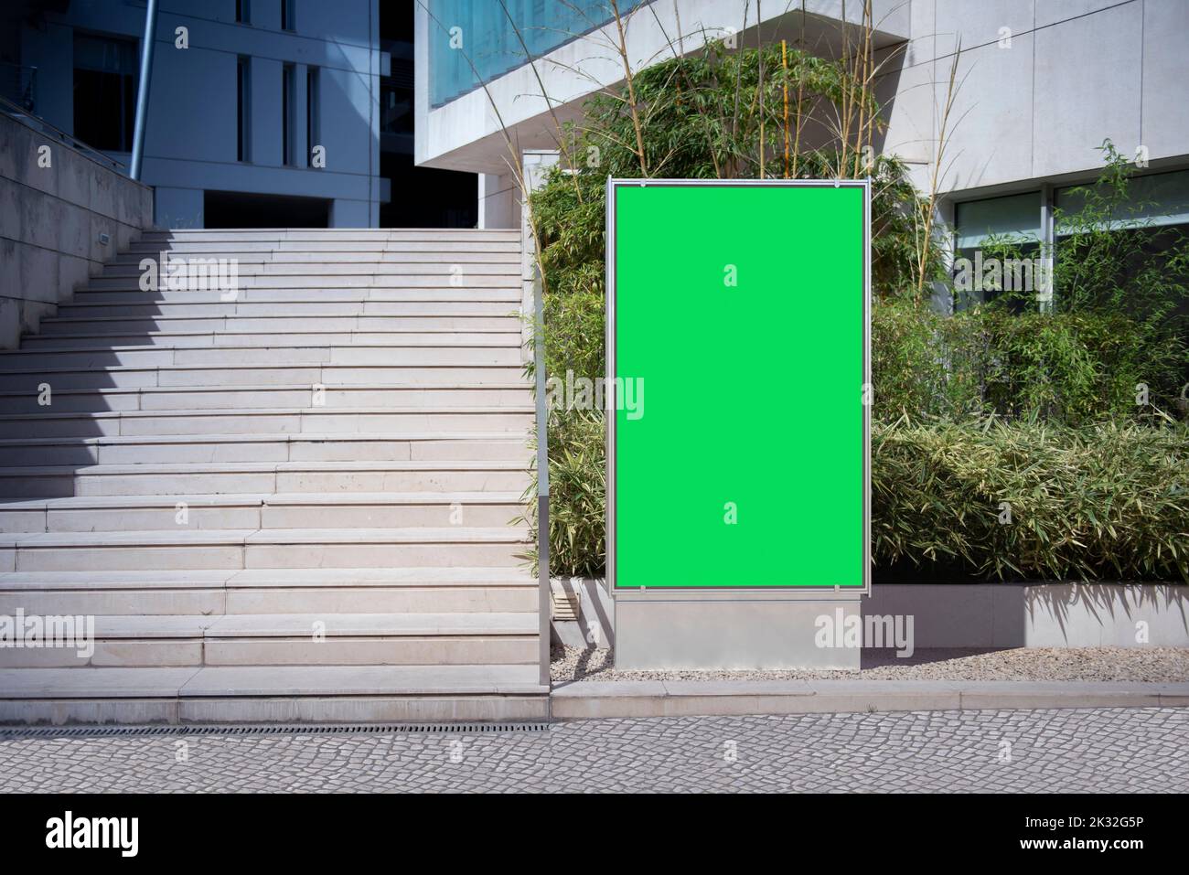 Vertical billboard mockup with green screen in the street next to the ...