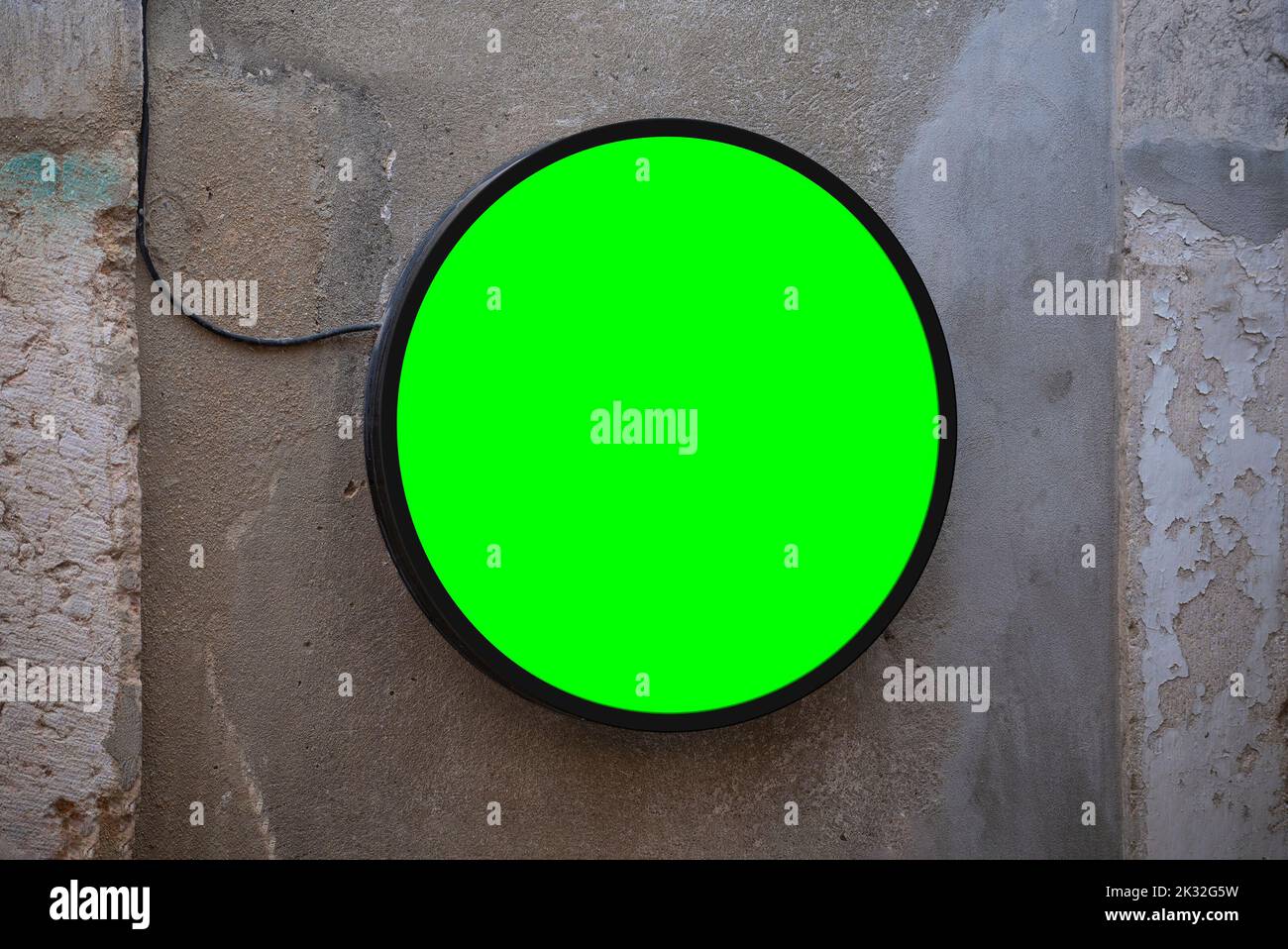 Round banner on the old concrete wall. Black circle signboard for logo ...