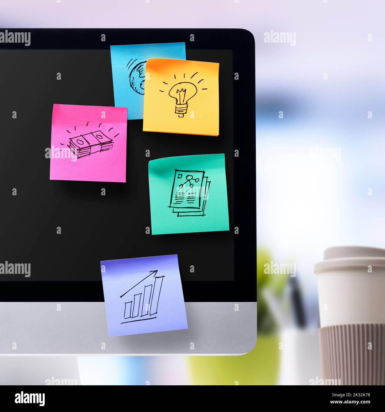 Sticky notes with sketched business icons on office computer screen ...
