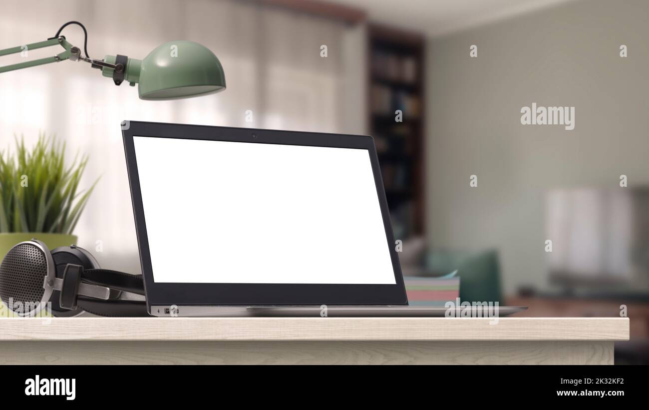Laptop with blank screen on a desktop at home, room interior in the ...