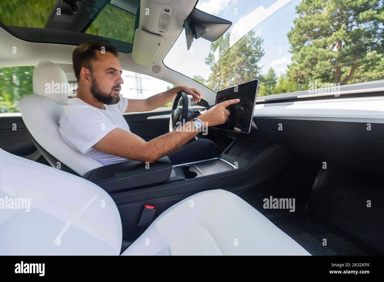 Caucasian man driving a modern electric car Stock Photo - Alamy