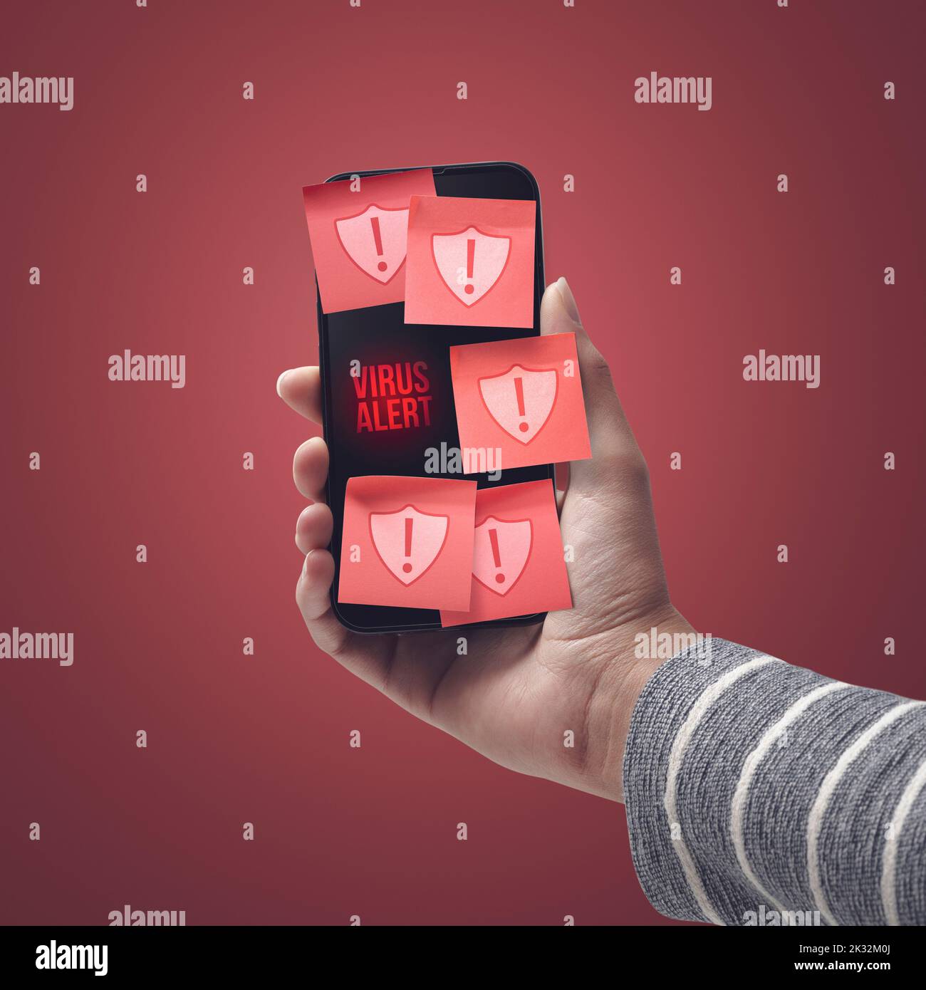 Hand holding a smartphone showing antivirus warnings, the device is ...