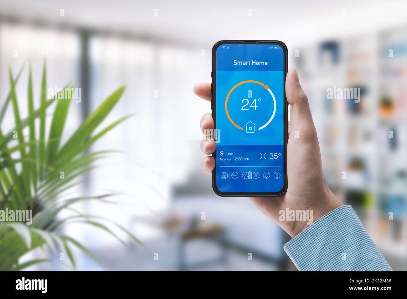 Woman setting home temperature using her smartphone, smart home ...