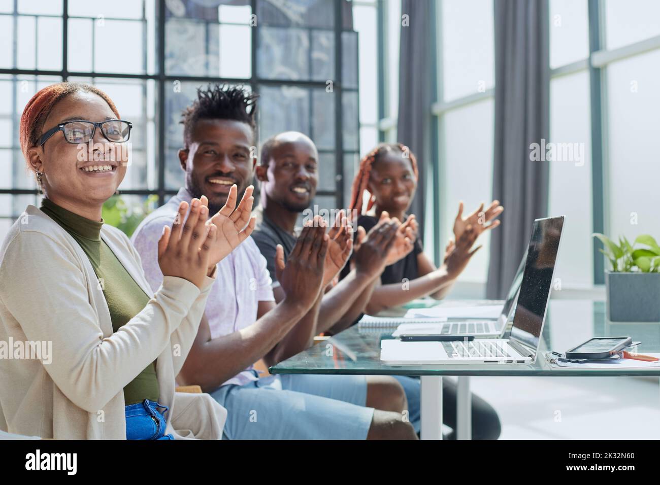 Multi ethnic business group greets somebody with clapping and smiling ...