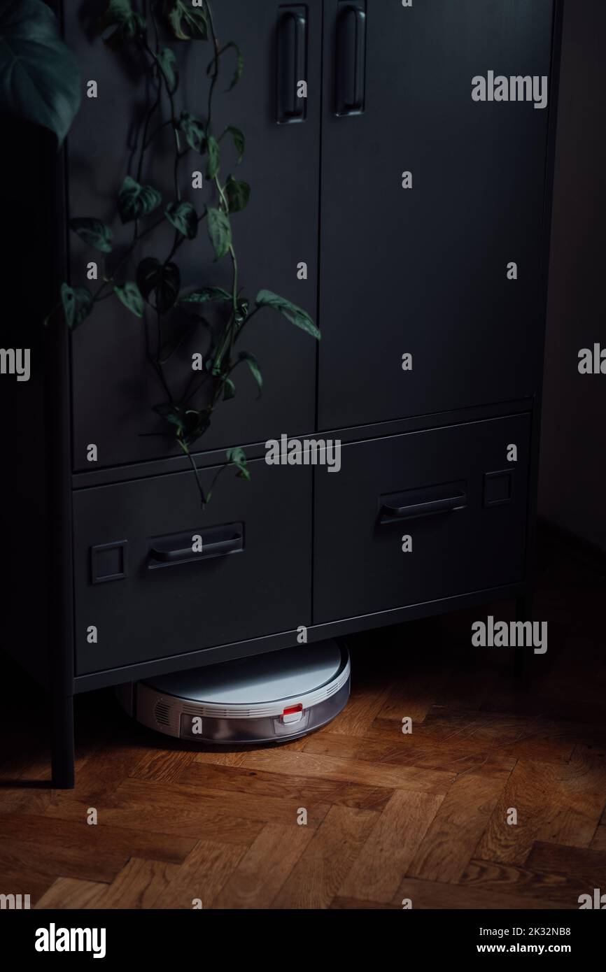 A robot vacuum cleaner under the shelf Stock Photo - Alamy