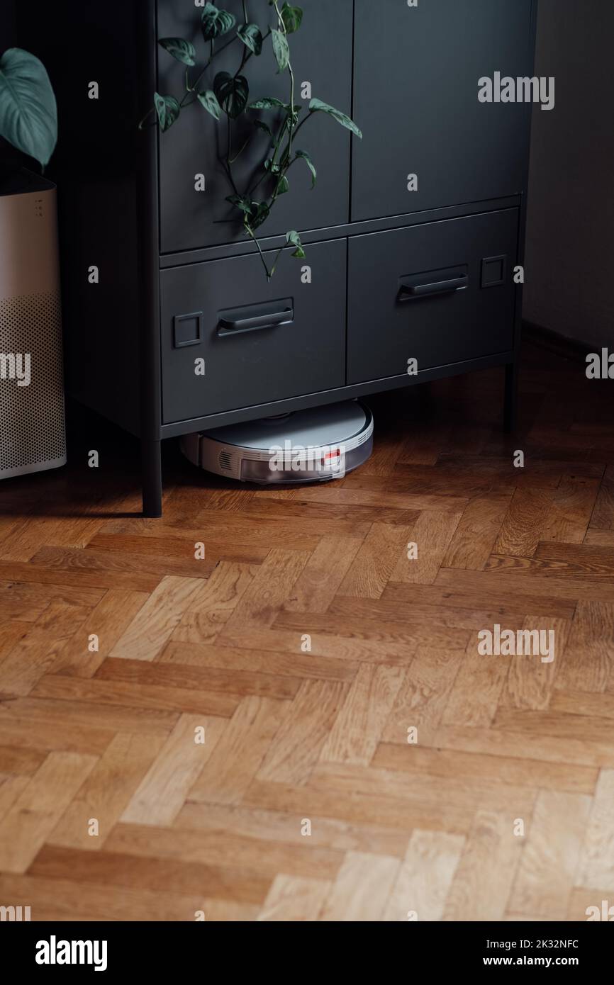 A robot vacuum cleaner under the shelf Stock Photo - Alamy
