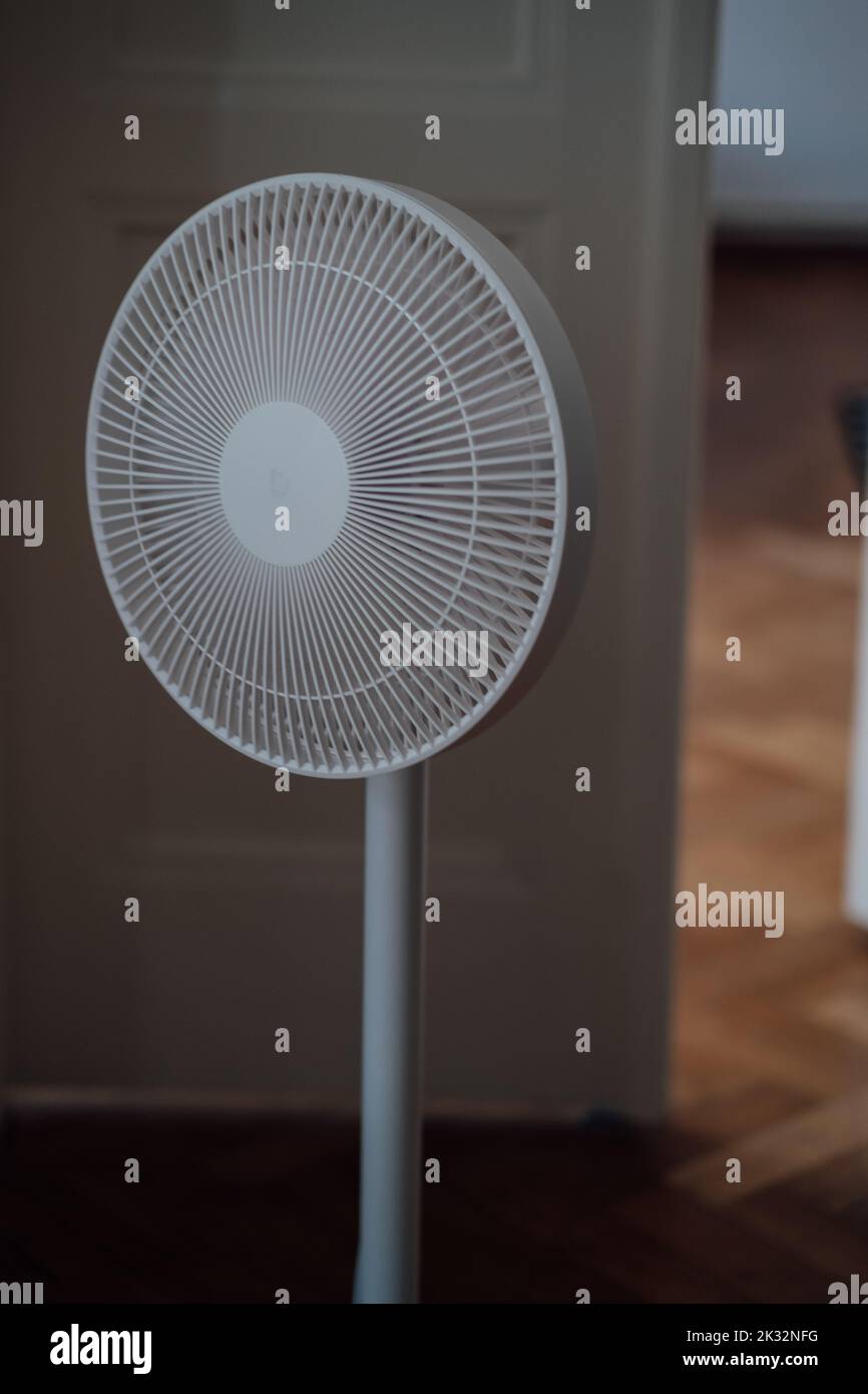 A white standing fan in a room Stock Photo - Alamy
