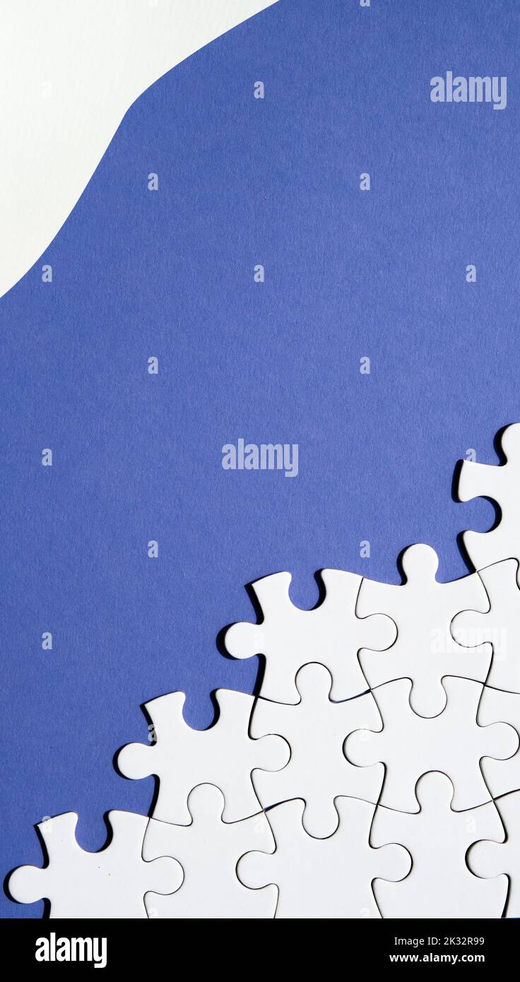 Jigsaw puzzle pieces half assembled and separate. Top view, flat lay on ...