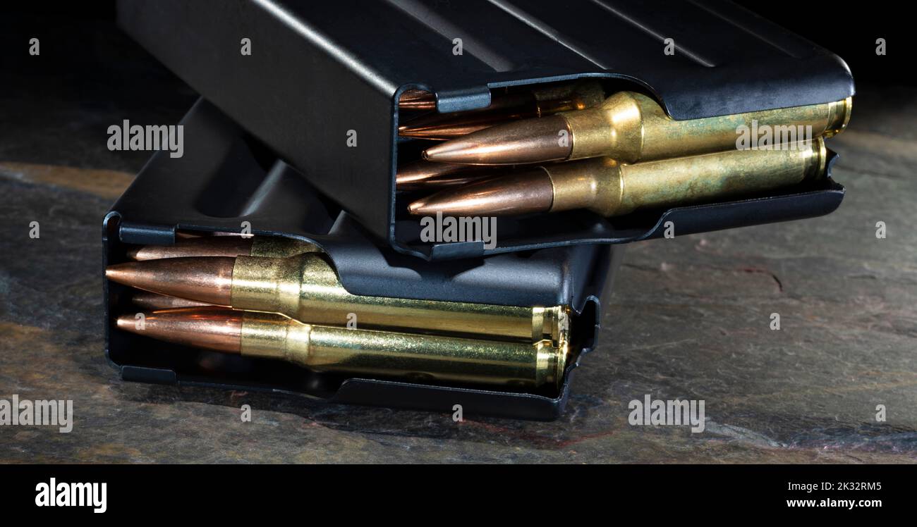 Metal magazines loaded with bullets on a dark stone Stock Photo - Alamy