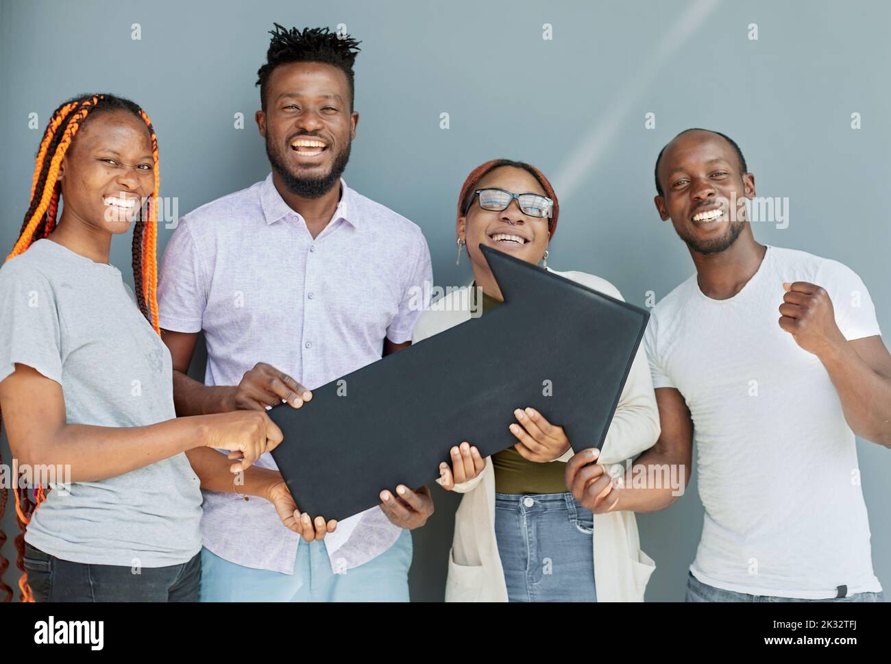 Young african american friends holding black arrow Stock Photo - Alamy