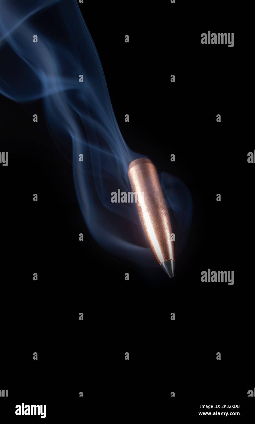 Bullet falling to the ground with smoke behind on a black background ...