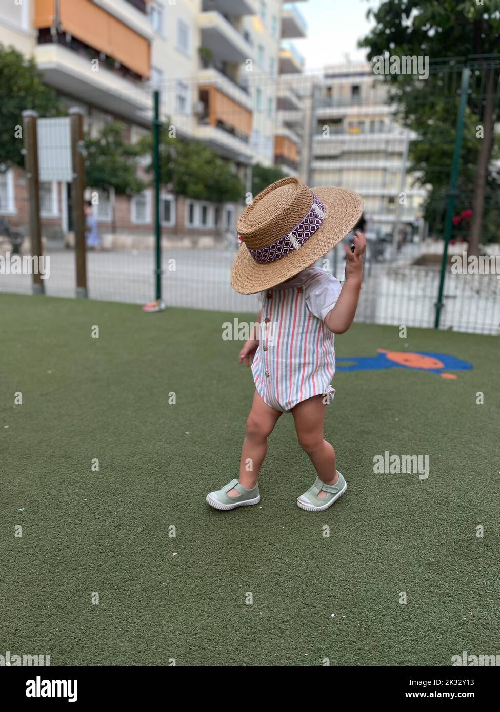 A baby boy playing in a park with a hat that covers his eyes Stock ...