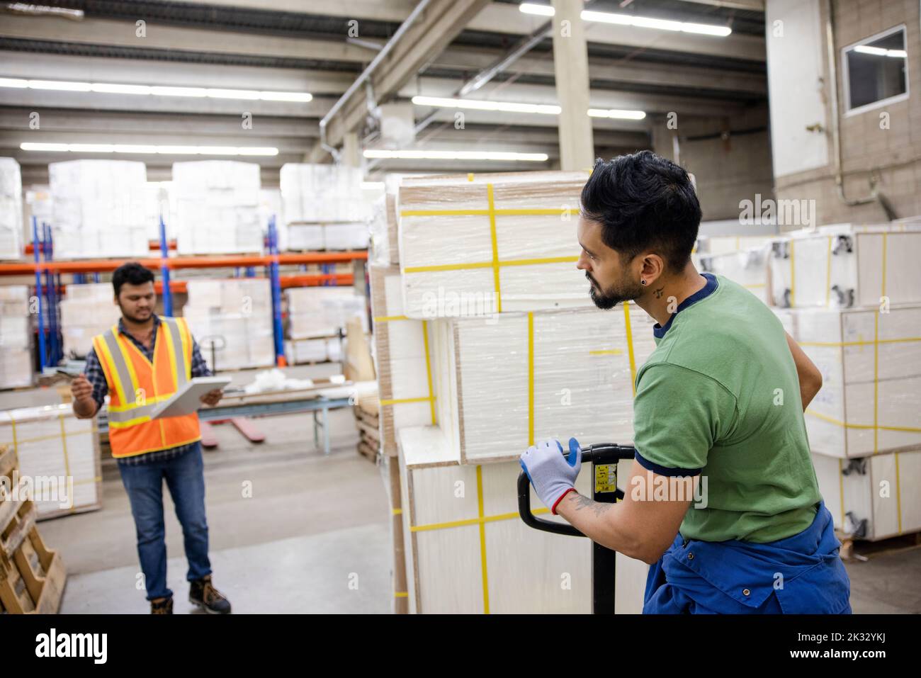 Workers moving cargo in distribution warehouse Stock Photo - Alamy