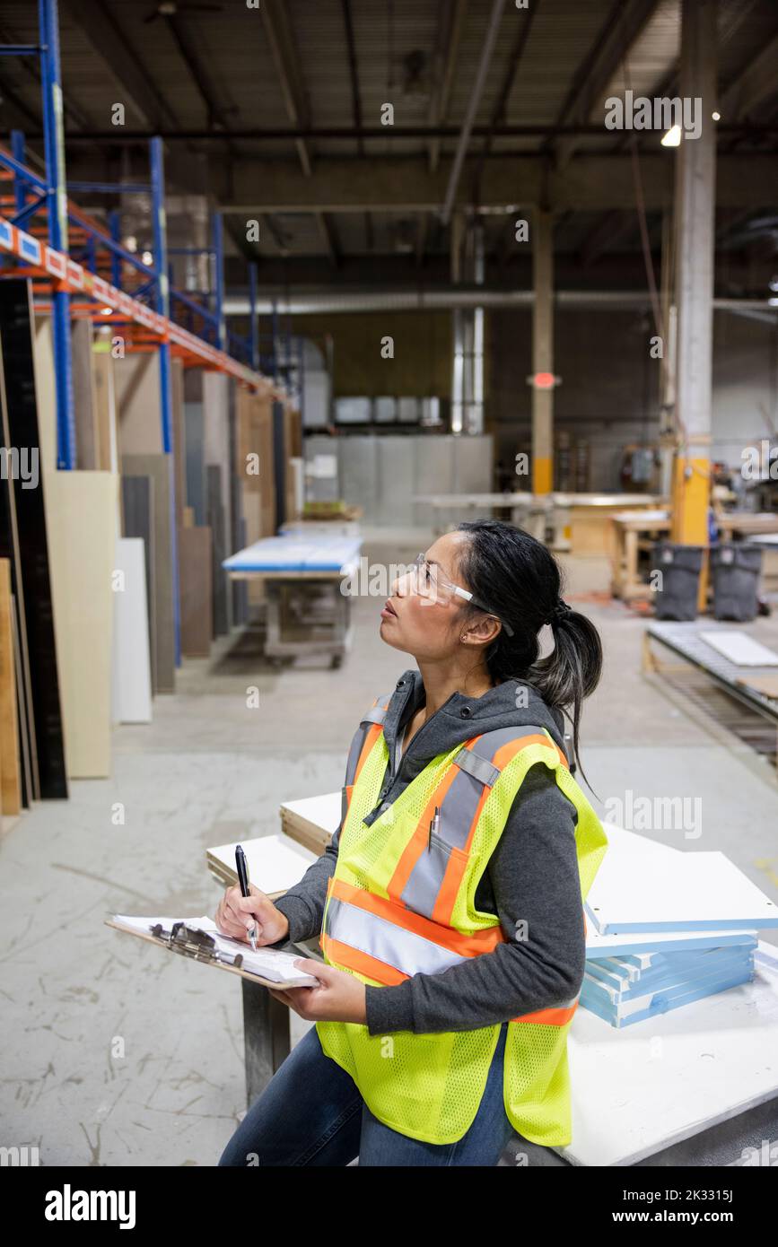 Worker checking stocks in distribution warehouse Stock Photo - Alamy