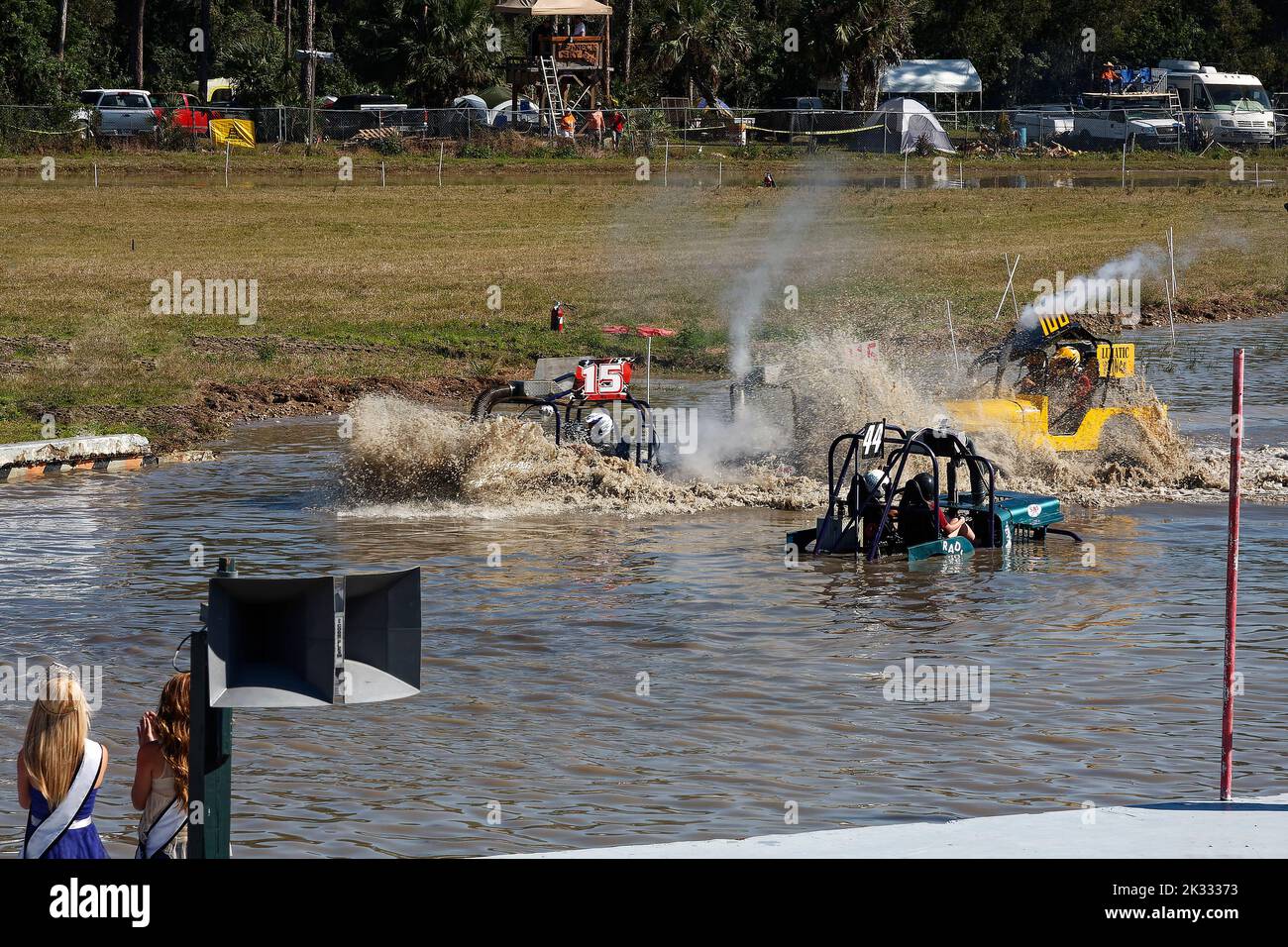 3 swamp buggies, racing, going in opposite directions, water splashing ...