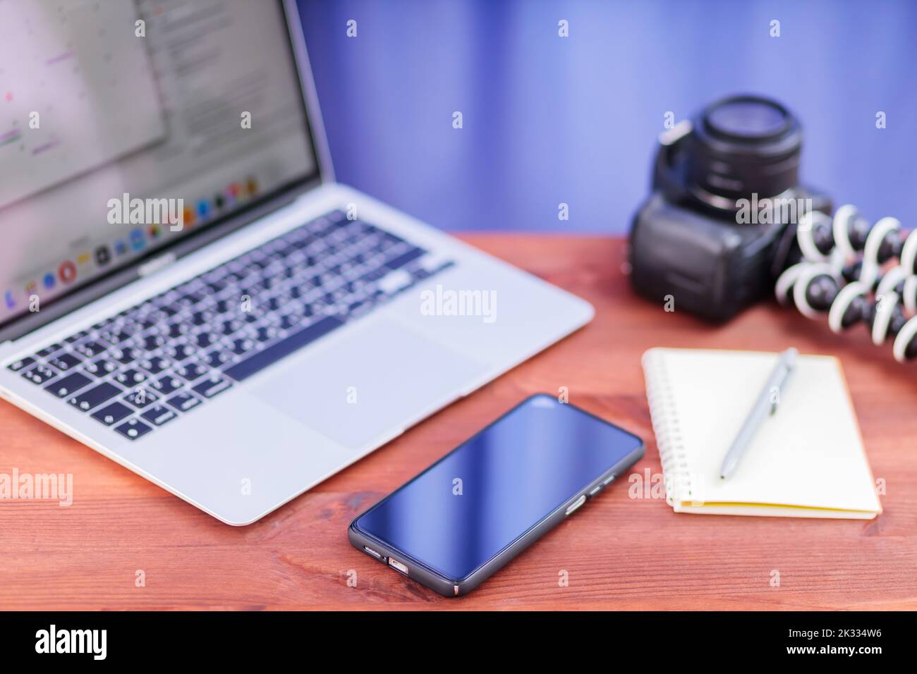 Vlogger workplace. Laptop, smartphone, notebook and camera on a wooden ...