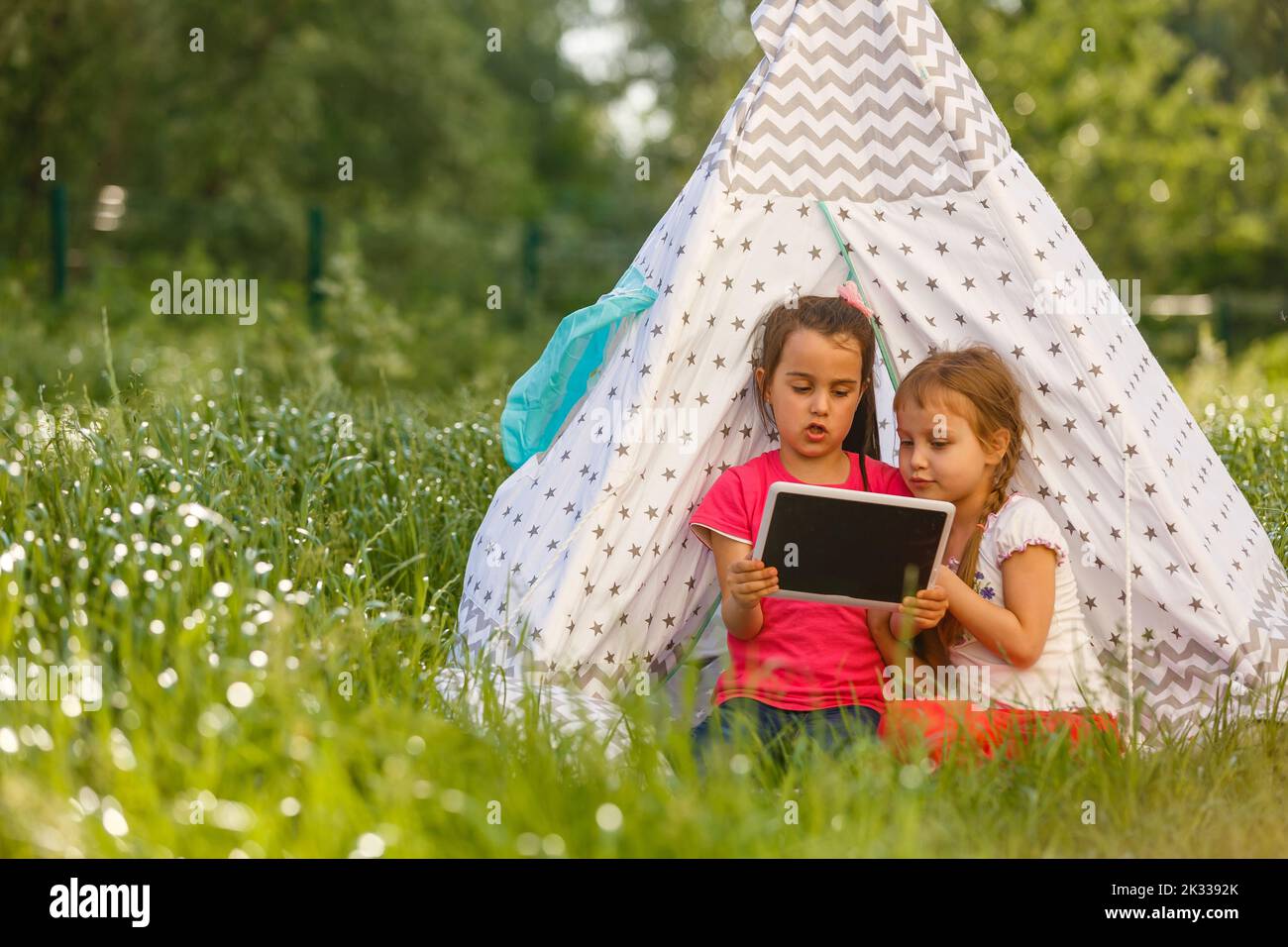 children playing in tablet pc in a tent Stock Photo - Alamy